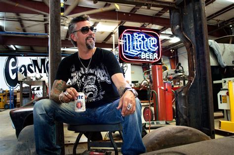 A Man Sitting On Top Of A Chair In A Garage