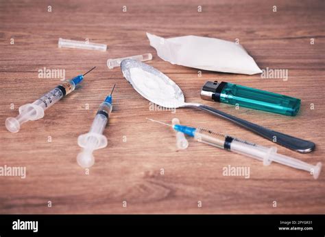 Polvo jeringa y drogas con cuchara en la mesa para la adicción al