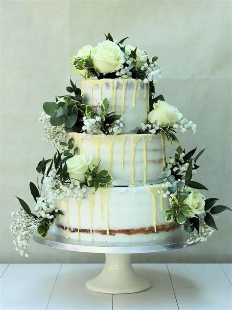 Semi Naked Drip Cake With Green And White Loose Flower Clusters Bay