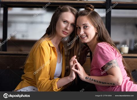 Two Smiling Lesbians Touching Hands Looking Camera Living Room Stock