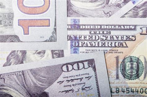 Una pila de billetes de 100 dólares y un billete de cien dólares Foto