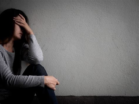 Mulher Deprimida Que Senta Se Em Uma Cadeira Na Sala Escura Em Casa