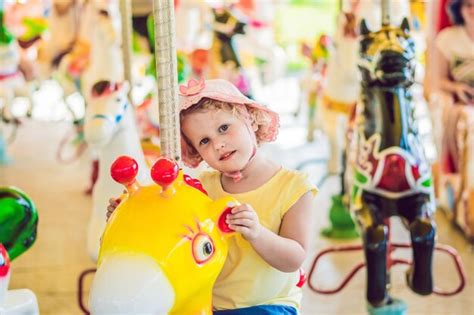 Menina bonitinha curtindo no parque de diversões e andando na colorida