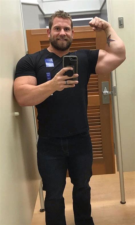 A Man Taking A Selfie In The Mirror With His Cell Phone And Showing Off