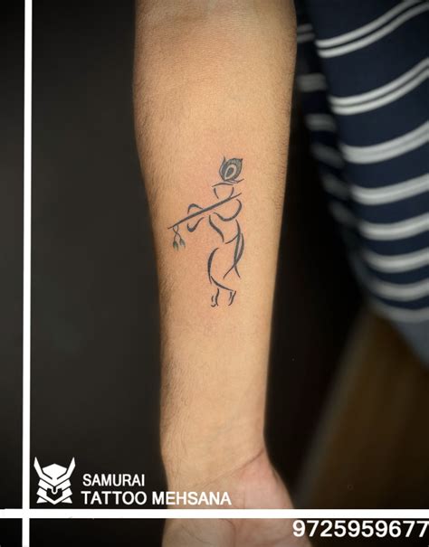 A Person With A Tattoo On Their Arm Holding A Stick And Ball In One Hand