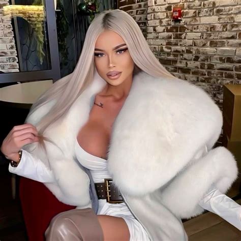 A Woman In White Fur Coat Posing For The Camera