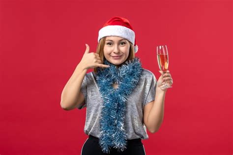 Vista frontal joven mujer celebrando el año nuevo en la pared roja