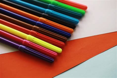 Lápices de colores y flomasters coloridos en el fondo de papel foto de