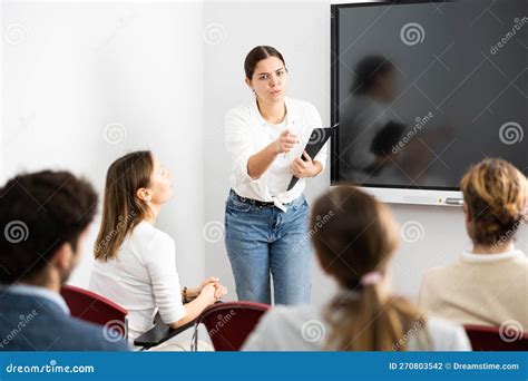 Profesora Joven Explicando El Tema En Un Aula Llena De Estudiantes Foto
