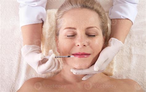 une femme d âge moyen reçoit une injection cosmétique dans ses lèvres