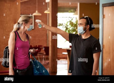 Middle Aged Caucasian Female Wearing Pink Tank Top And Face Mask Having Temperature Checked