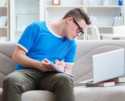 Foto De Un Joven Estudiante Que Estudia Para Los Exámenes En Casa En Un