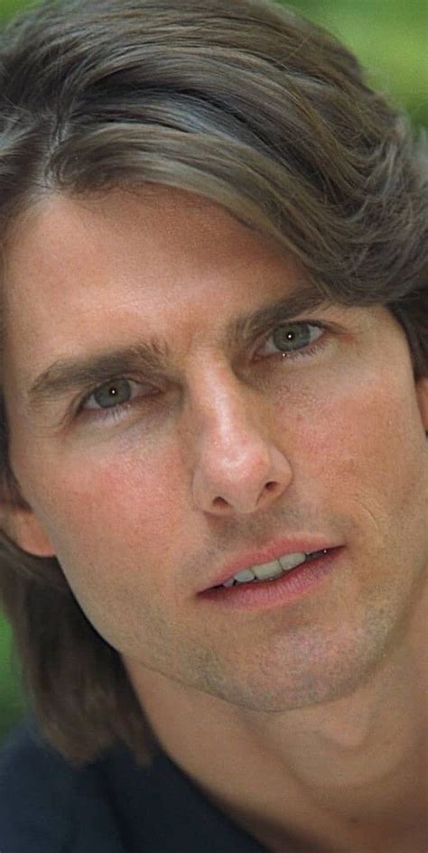 A Close Up Of A Person Wearing A Suit And Tie With Trees In The Background