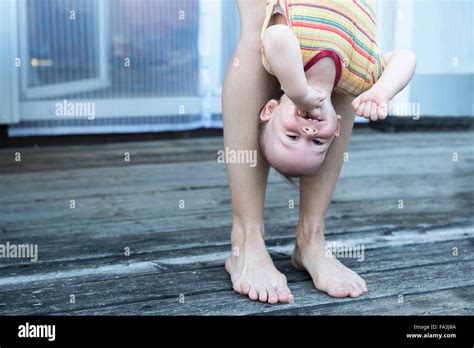 Mother Holding Her Baby Son Upside Down And Laughing Munich Bavaria