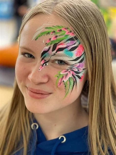 A Girl With Painted Face And Hair Smiling At The Camera While Looking