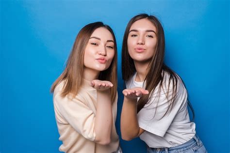 Junge Zwei Frauen Blasen Kuss Isolierte Blaue Wand Kostenlose Foto