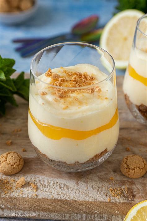Two Glasses Filled With Dessert Sitting On Top Of A Cutting Board Next