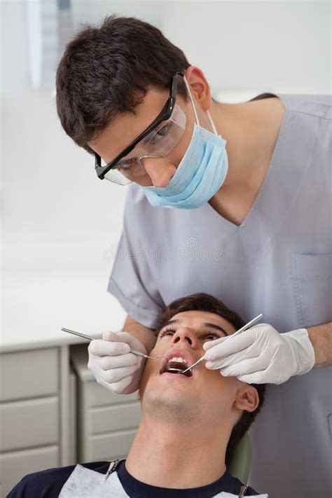 Dentista O Paciente Que Olha Os Dentes Foto De Stock Imagem De