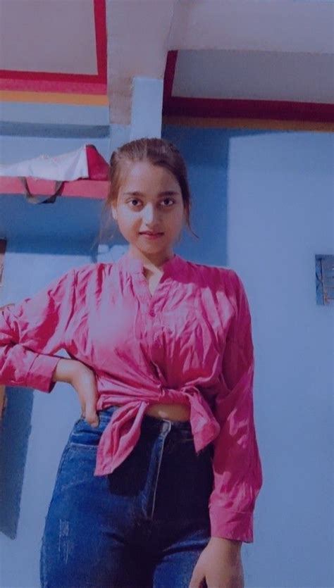 A Woman In Pink Shirt And Jeans Posing For The Camera