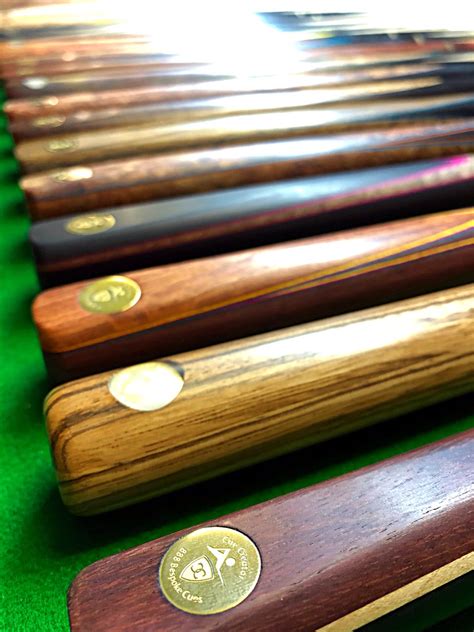 Several Wooden Baseball Bats Lined Up On A Green Surface