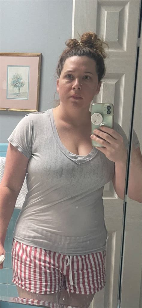 A Woman Taking A Selfie In Front Of A Bathroom Mirror With Her Cell Phone