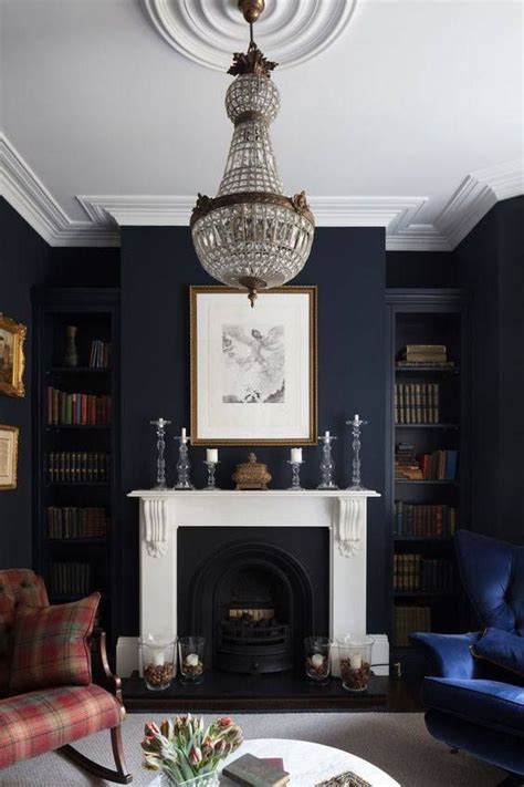 A Living Room Filled With Furniture And A Fire Place Under A Chandelier