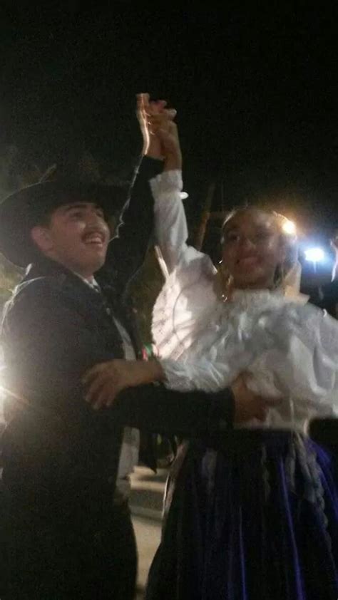 A Man And Woman Dressed In Colonial Clothing Dancing At Night With