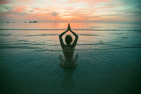 Silueta De Joven Mujer De Yoga En La Playa En La Puesta De Sol