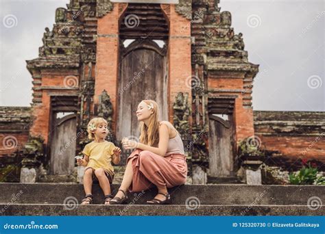 Touristes De Maman Et De Fils Dans Le Temple Hindou Traditionnel Taman