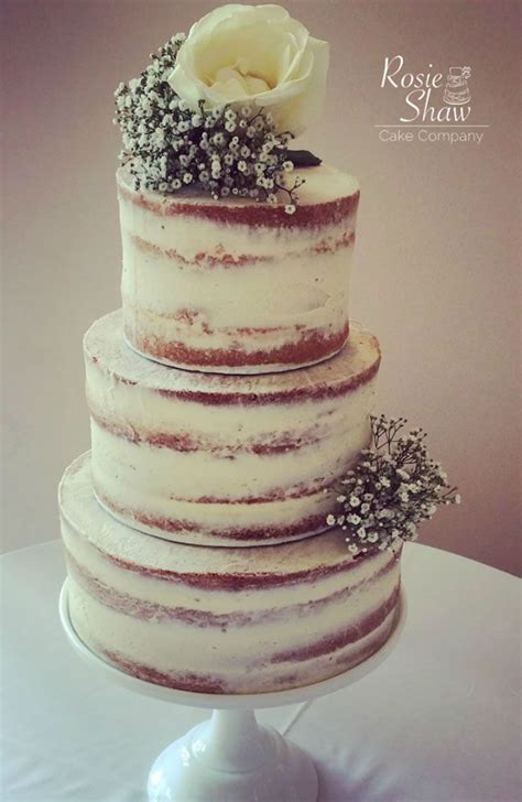 A Three Tiered Cake With Flowers On Top