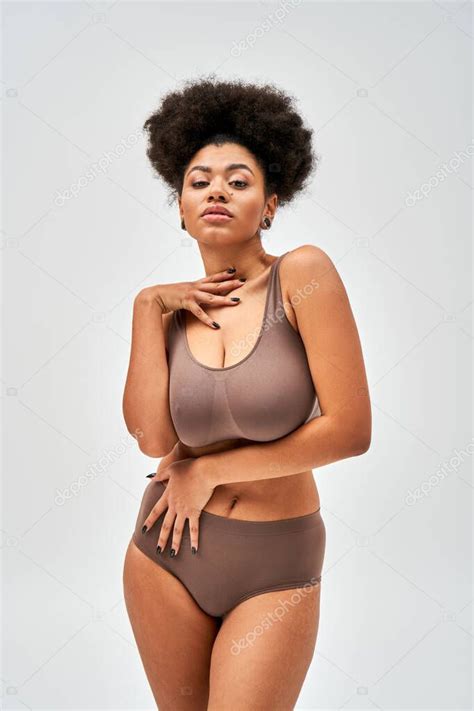 Retrato de mujer afroamericana seductora en lencería marrón moderna