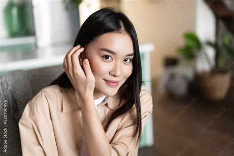Portrait Of Asian Woman Smiling Sitting At Home Girl Touches Her Hair And Looks Cute At Camera
